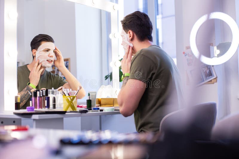 Curious Tattooed Guy Testing New Face Mask while Sitting in Studio ...