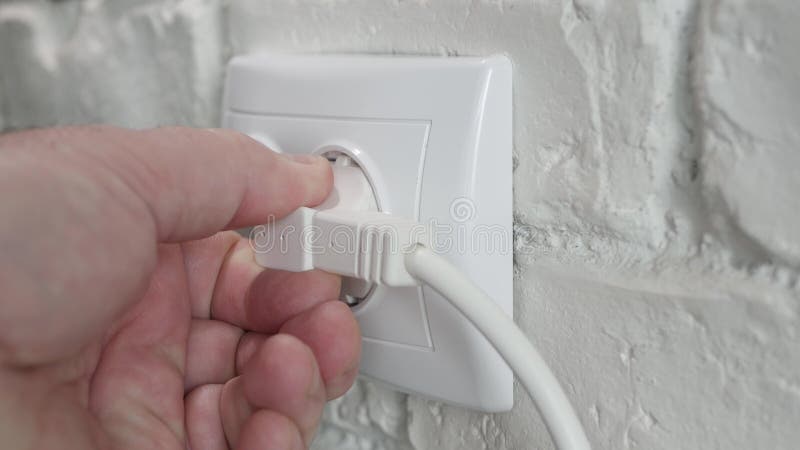 Unplugging an Electrical Power Cord from a Wall Socket in the Office ...