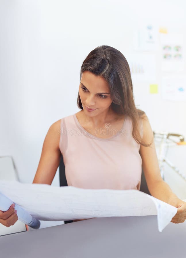 Taking a Quick Look Over the Plans. a Young Architect Looking Over Some ...