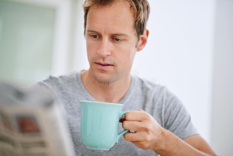 Taking Things Easy. a Handsome Man Reading the Paper while Drinking ...
