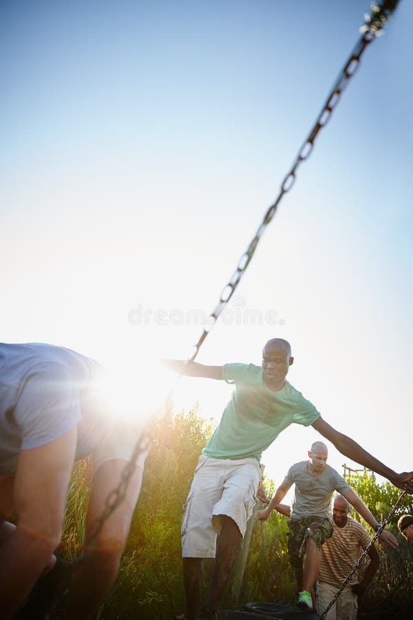 Taking Up the Challenge. a Group of Men Going through an Obstacle ...