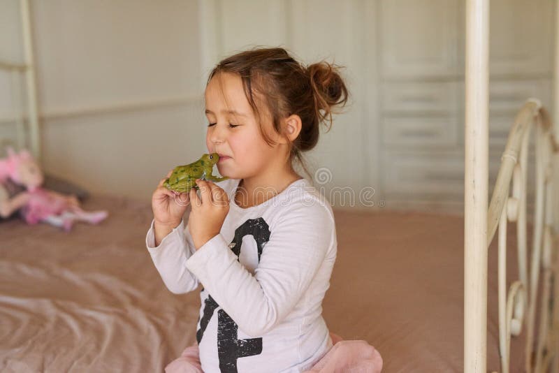 Tal Vez Se Convierta En Un Principito. Una Niña Pequeña Besando Una ... Tal Vez Se Convierta En Un Principito. Una Niña Pequeña Besando Una ...