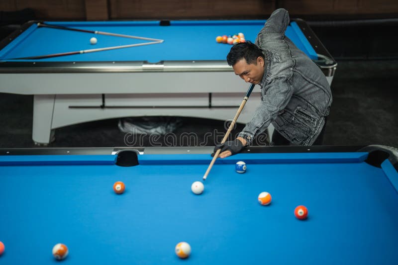 Talented Billiard Player Poking the White Ball during the Game Stock ...