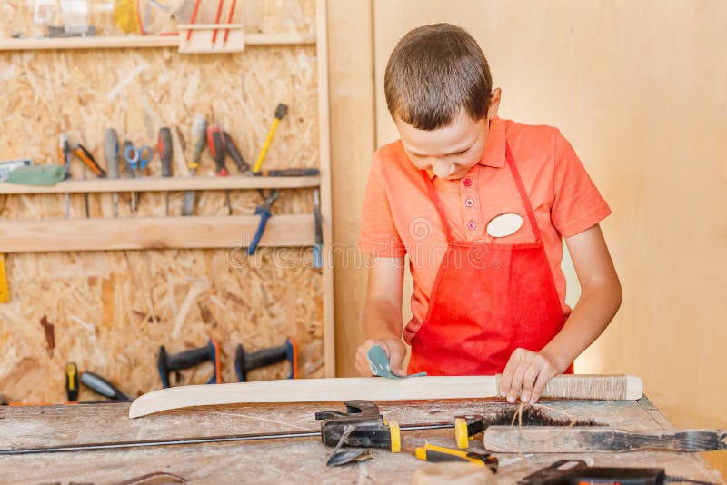 Talented Genius Boy Works with Wood in a Carpentry Workshop. the ...