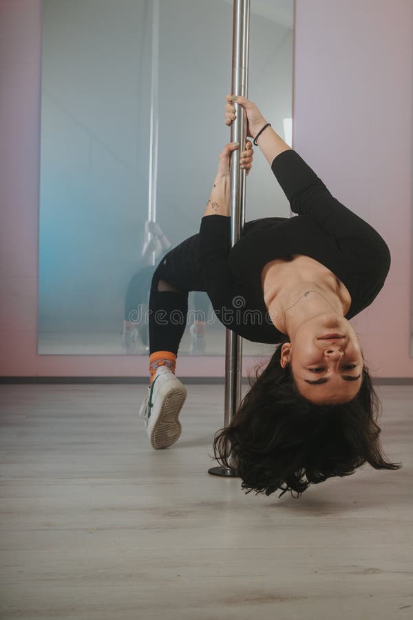 Person Performing a Pole Dancing Routine with Grace and Strength in a ...