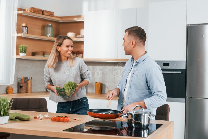 Talking with Each Other. Couple Preparing Food at Home on the Modern ...
