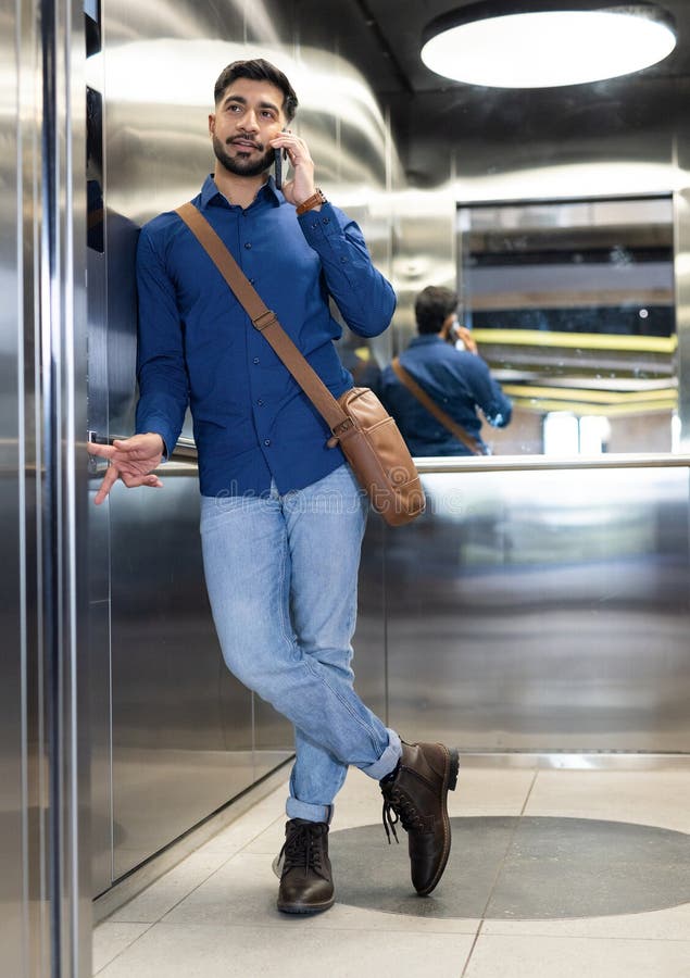 Talking on Smartphone, Man in Elevator with Messenger Bag, Looking ...