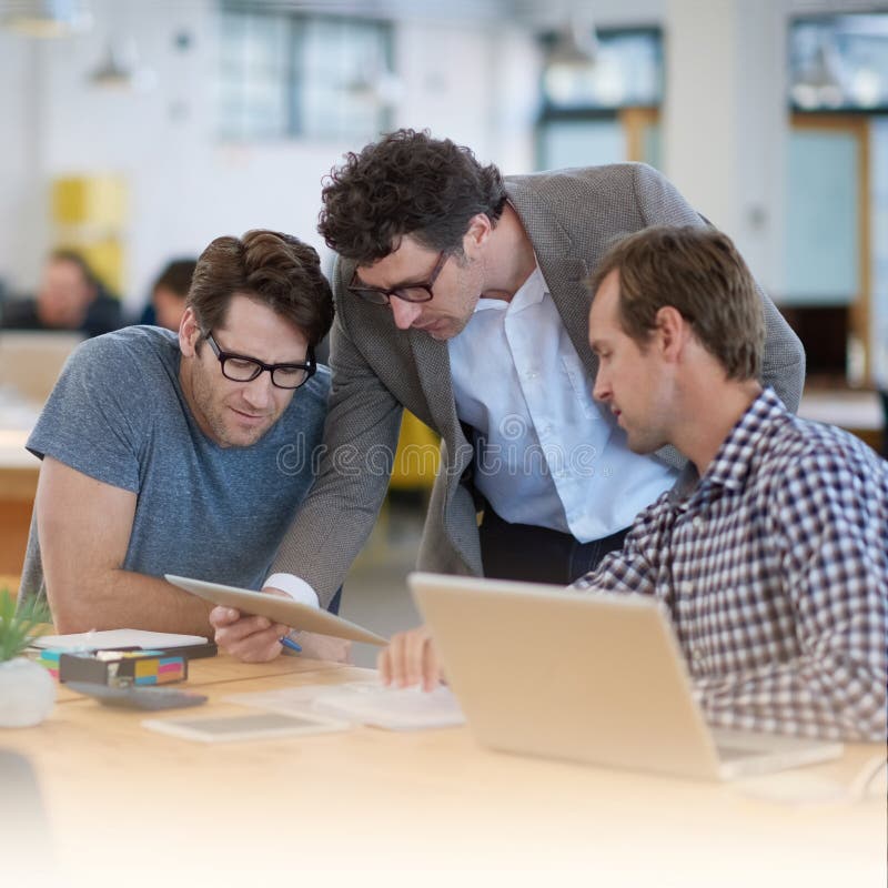 Talking Technology in the Workplace. Colleagues Talking Together Over a ...