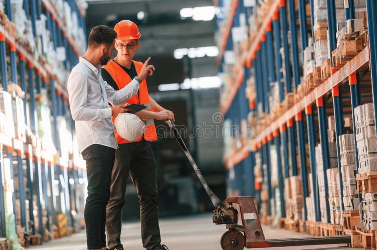 Talking To Each Other. Two Storage Workers is in the Warehouse Stock ...