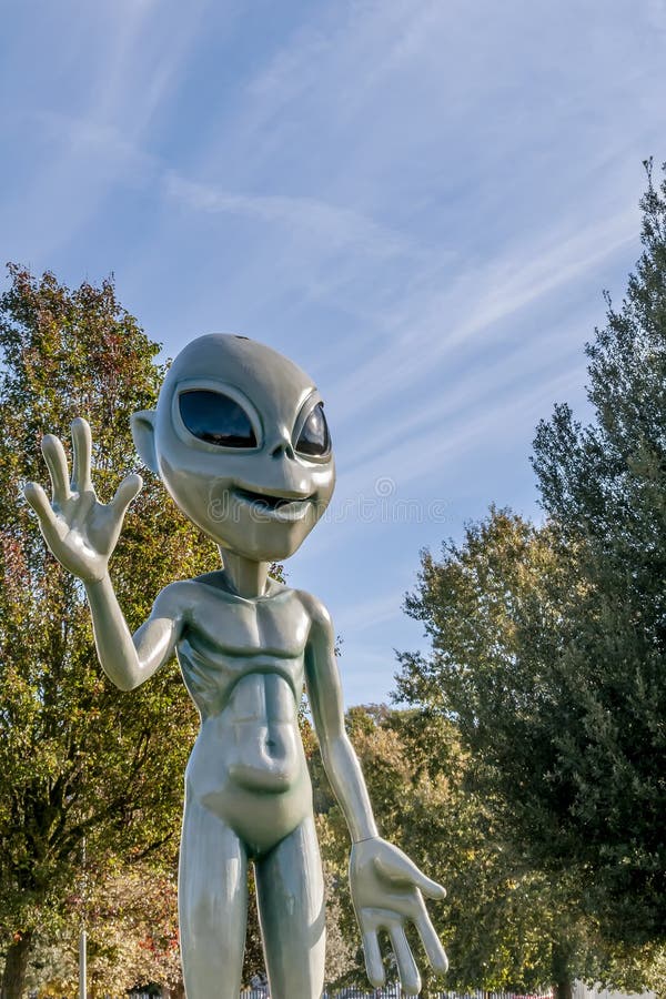 A Large Alien Waves with a Four-fingered Hand, Surrounded by Trees ...