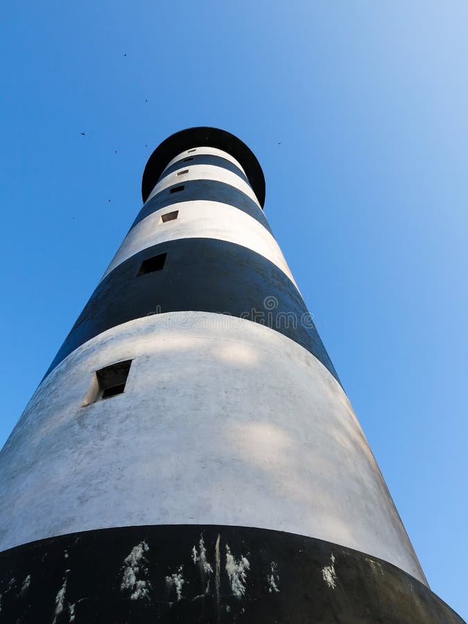 Tall Black and White Striped Lighthouse on Blue. Stock Image - Image of ...