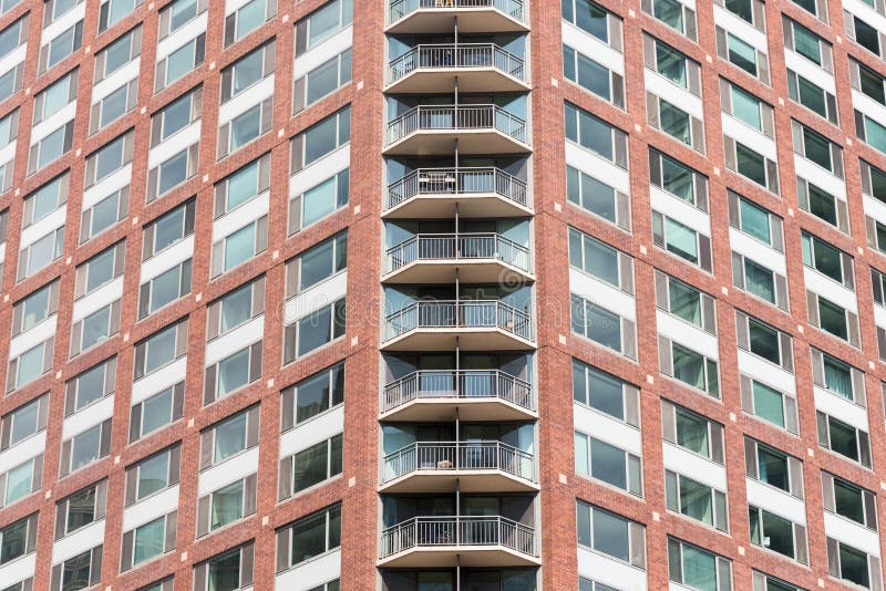 A Tall Brick Building with Balconies and Windows Stock Photo - Image of ...