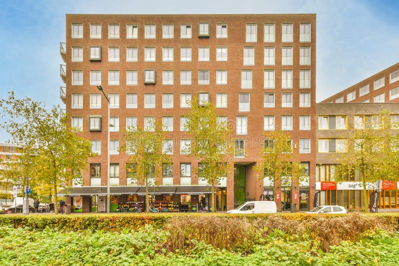 A Tall Brick Building with Trees in Front of it Editorial Stock Image ...