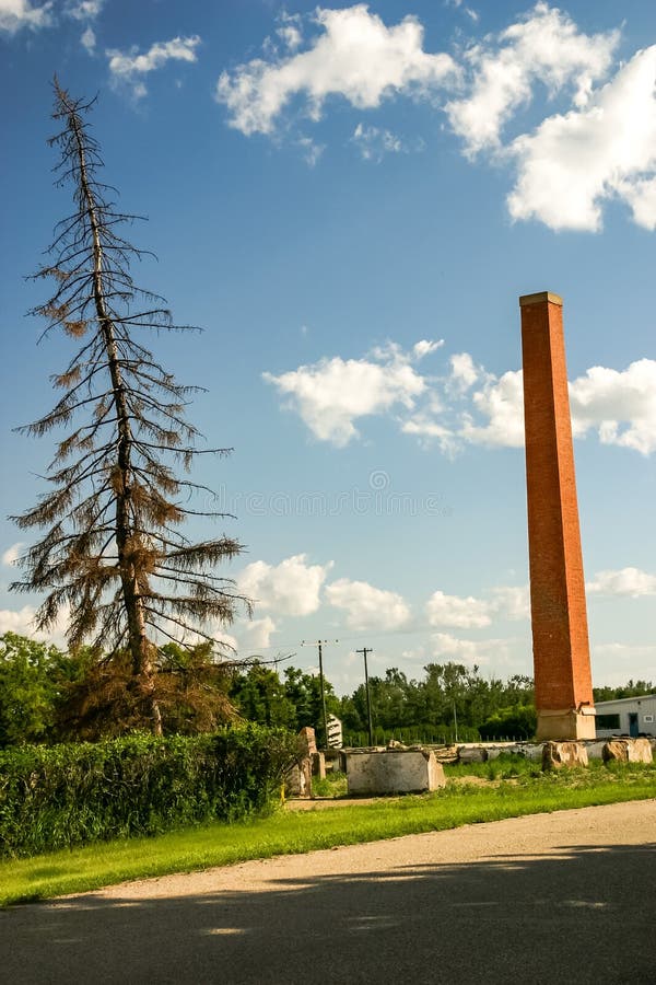 A Tall Brick Chimney Stands Next To a Tree Stock Photo - Image of ...