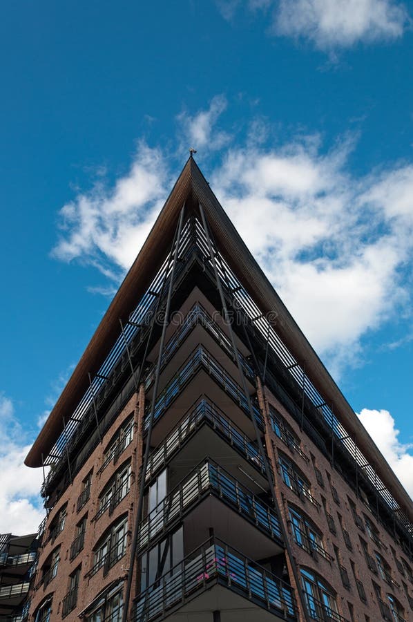 Tall Building with Angled Roof Against the Blue Sky Stock Image - Image ...