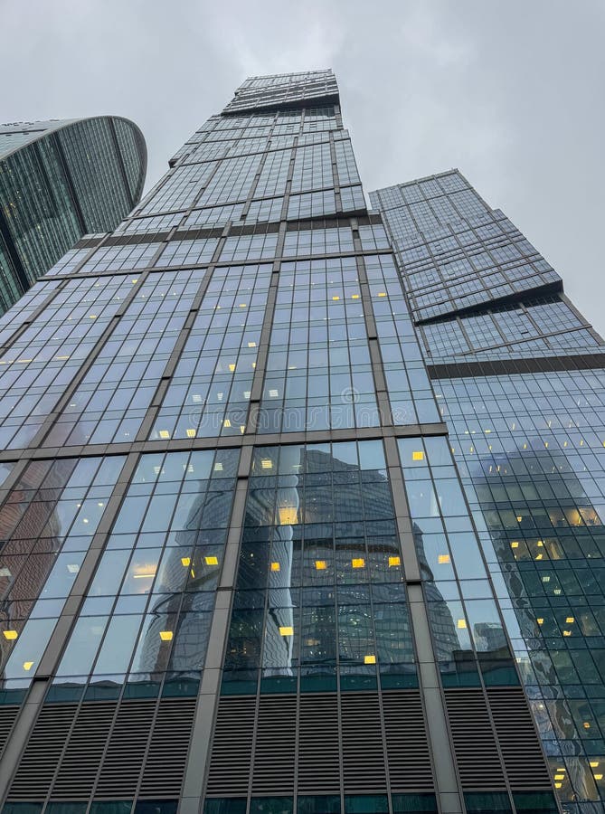 A Tall Building with Many Windows and a Reflection of the Sky Stock ...