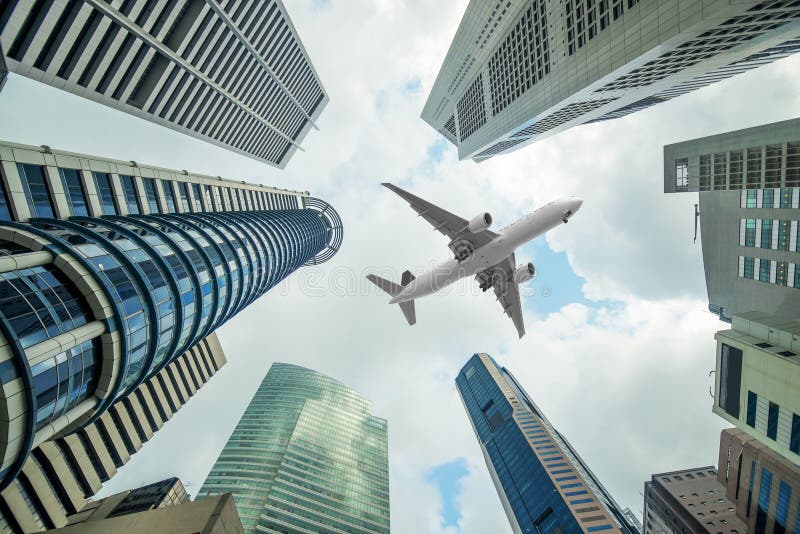 Tall City Buildings and a Plane Flying Overhead in Morning Stock Photo ...