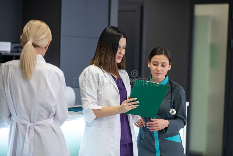 Tall Dark-haired Doctor Holding Assignment Sheet in Her Hands Stock ...