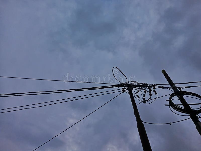 Tall Electricity and Network Pole with Its Cables Against Bright Cloudy ...