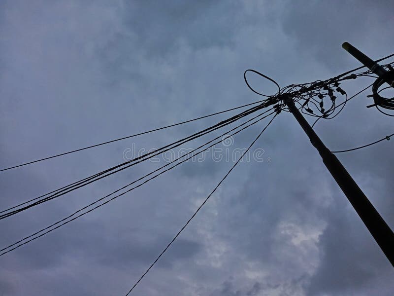 Tall Electricity and Network Pole with Its Cables Against Bright Cloudy ...