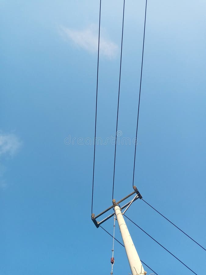 Tall Electricity Pole with Its Wires or Cables Against Clear Blue Sky ...