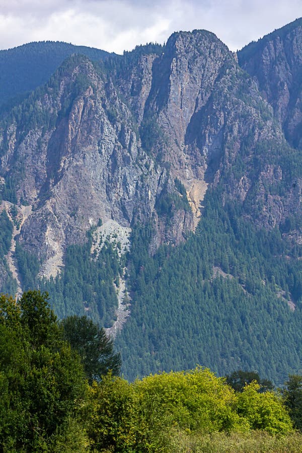 Tall Forested Mountain Cliffs Tower Over Trees Stock Image - Image of ...
