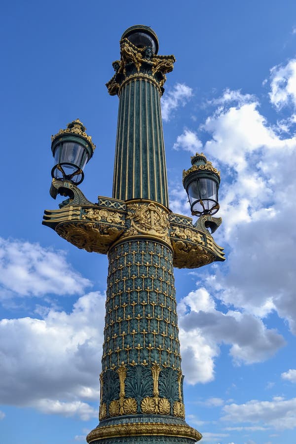 A Tall Green Lamp Post with Three Lights on Top. the Sky is Blue with ...