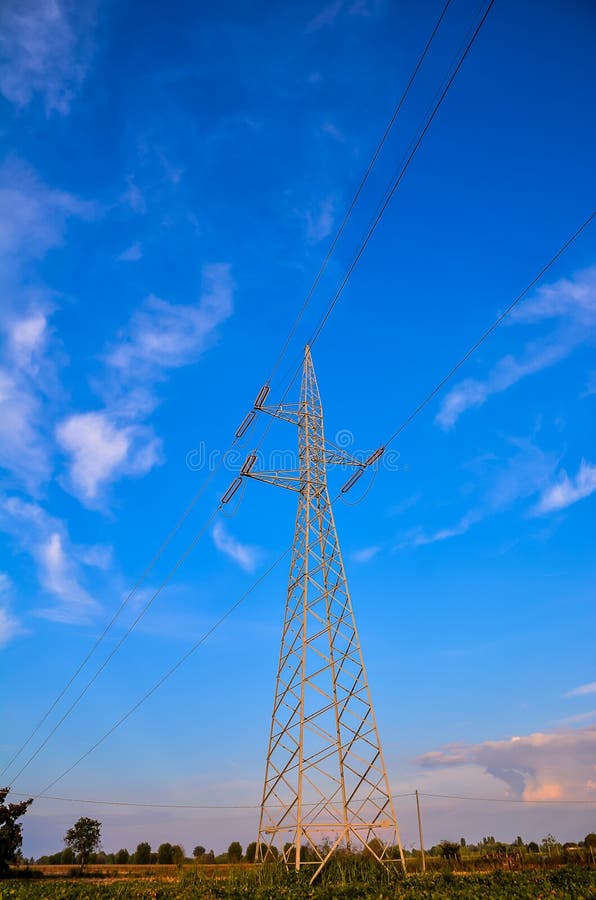 A Tall Power Tower is Standing in a Field with a Clear Blue Sky Stock ...