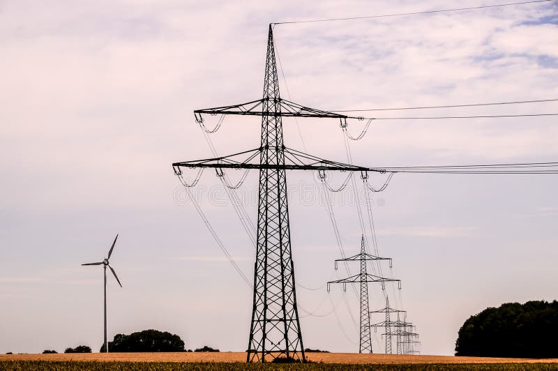 A Tall Power Tower with Three Other Towers in the Background Stock ...