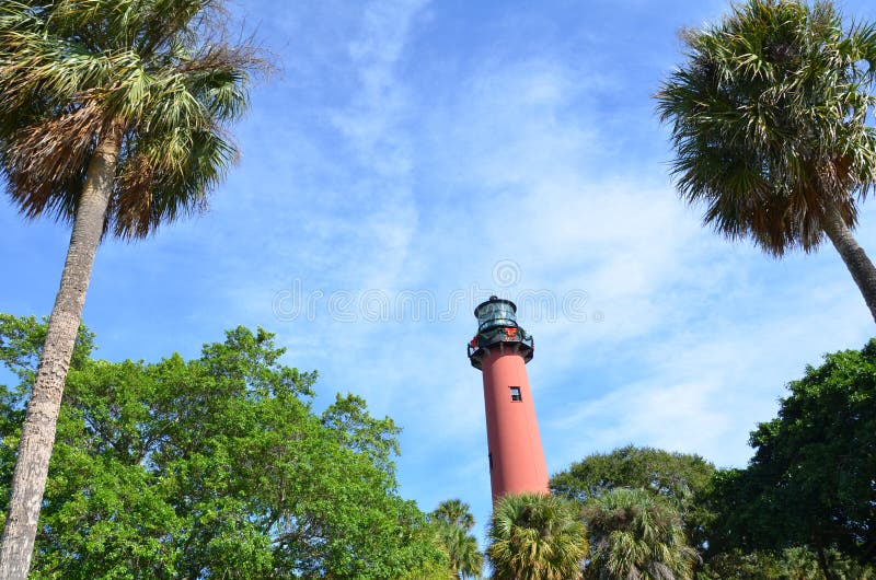 Tall Red Lighthouse with Green Grass and Trees Stock Photo - Image of ...
