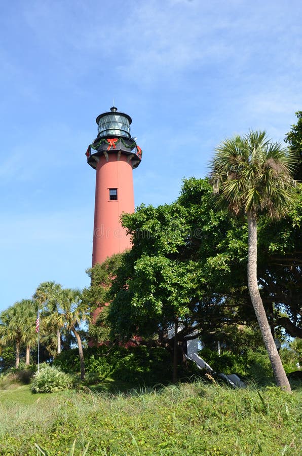 Tall Red Lighthouse with Green Grass and Trees Stock Photo - Image of ...