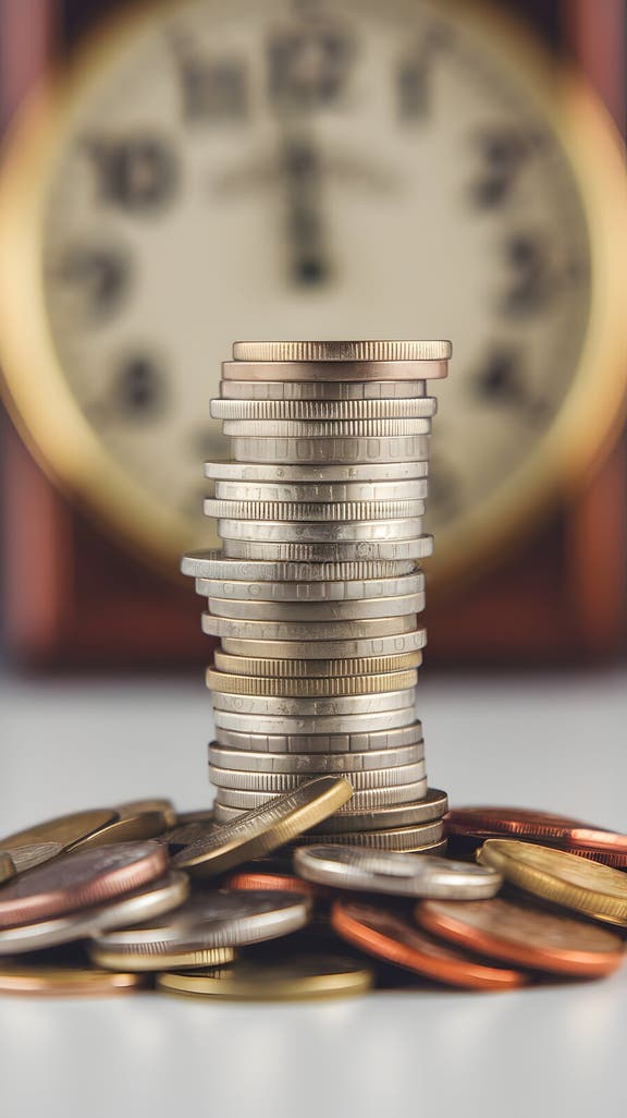 A Tall Stack of Silver Coins with Scattered Coins Below Stock ...