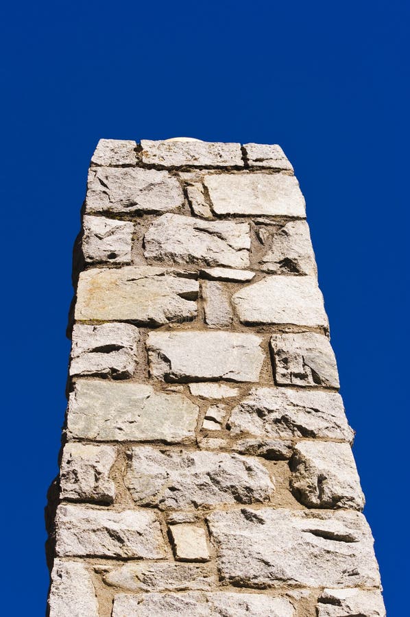 A Tall Old Stone Bell Tower Made of Red Brick Against a Blue Sky with ...