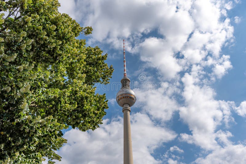 A Tall Tower with a Green Tree in the Background Stock Photo - Image of ...