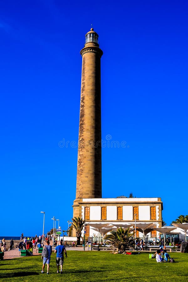 A Tall Tower with a Lighthouse on Top Stands in Front of a Building ...