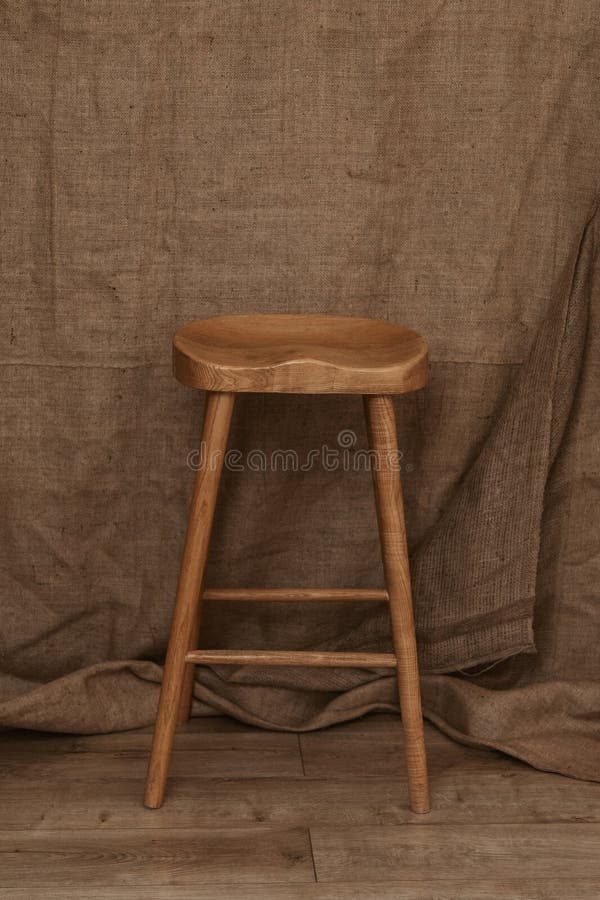 Tall Wooden Leg Stool on Brown Textile Background Stock Image - Image ...