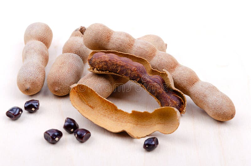 Tamarind Fruits, Whole, Cracked Open, and Seeds, on Wooden Surface ...