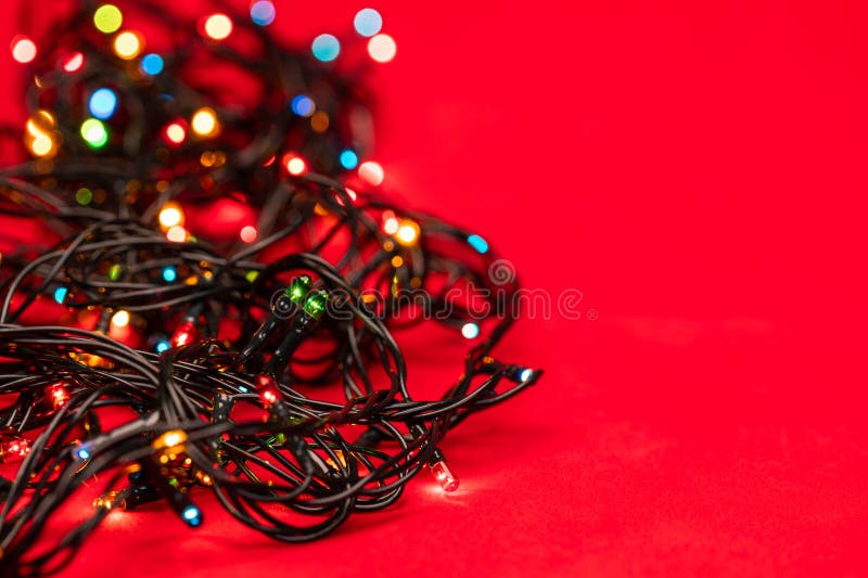 Tangle of Festive String Lights Glowing in Multiple Colors on a Red ...