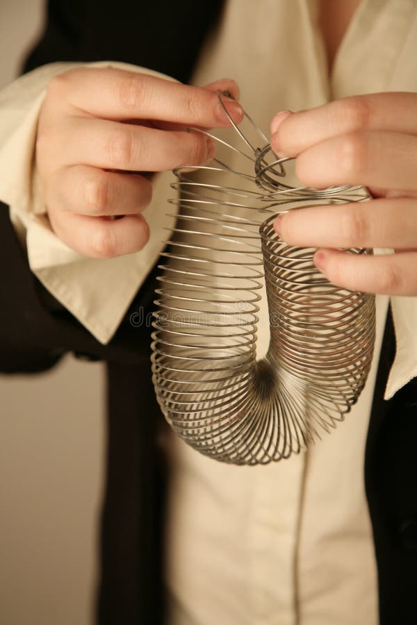 Tangled slinky editorial stock image. Image of round, hands - 6277164