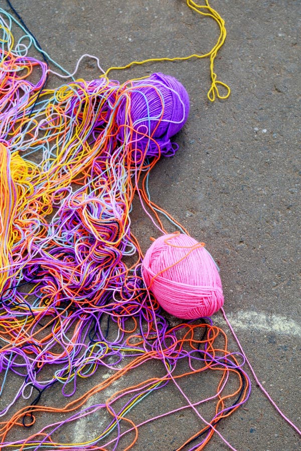 A Tangled Web of Multi-colored Knitting Threads Lies on the Asphalt ...