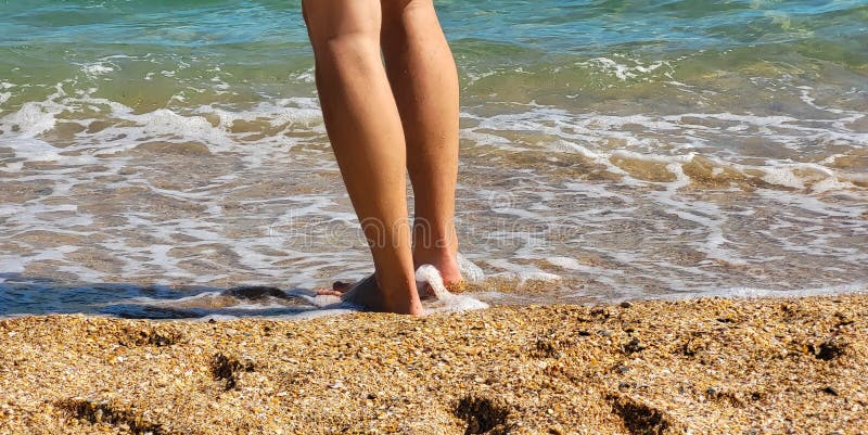 Tanned Legs in the Sea Waves on the Beach. the Concept of Recreation ...