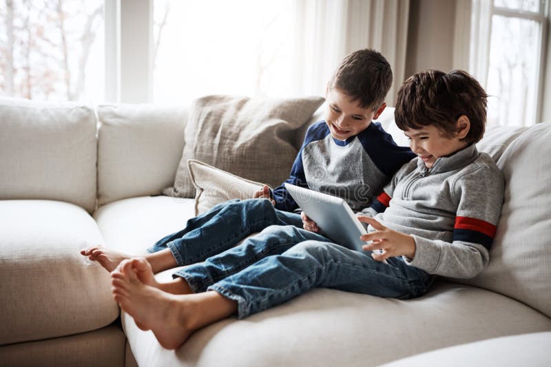 Tapped into a Digital World. Two Adorable Brothers Using a Digital ...