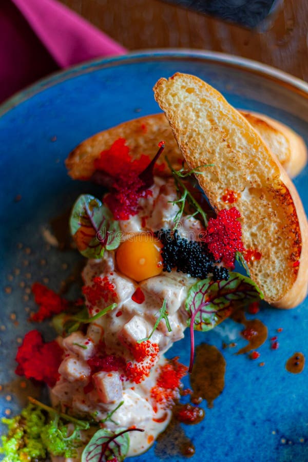 Tar tar on a blue plate stock photo. Image of head, drips - 210677168