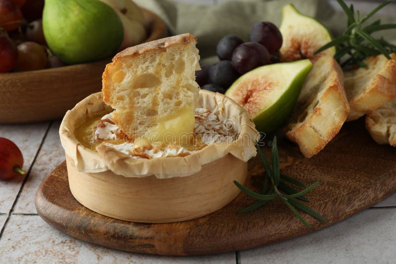 Tasty Baked Brie Cheese, Bread and Other Products on Light Tiled Table ...