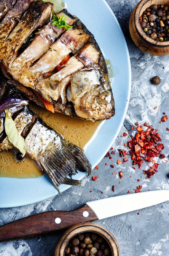 Tasty baked fish on plate stock photo. Image of food - 142392448