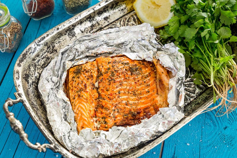 Tasty Baked Fish Salmon in Foil on Blue Table Stock Photo - Image of ...