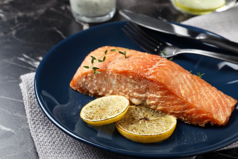 Tasty Cooked Red Fish with Lemon on Dark Marble Table, Closeup Stock ...
