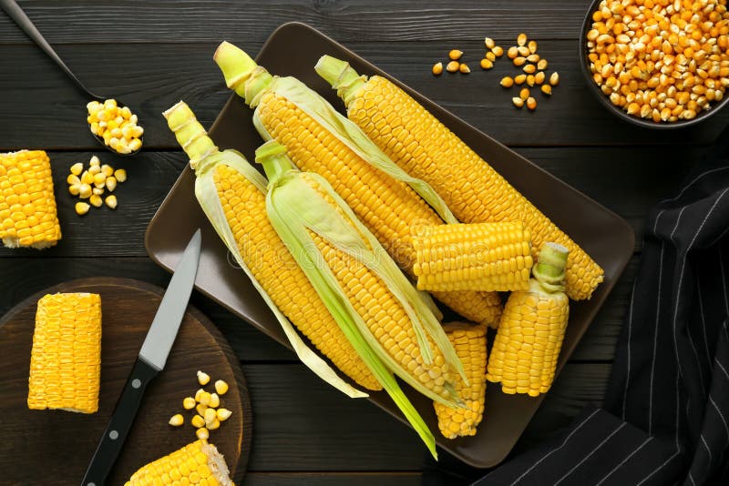 Tasty Fresh Corn Cobs and Kernels on Black Wooden Table, Flat Lay Stock ...