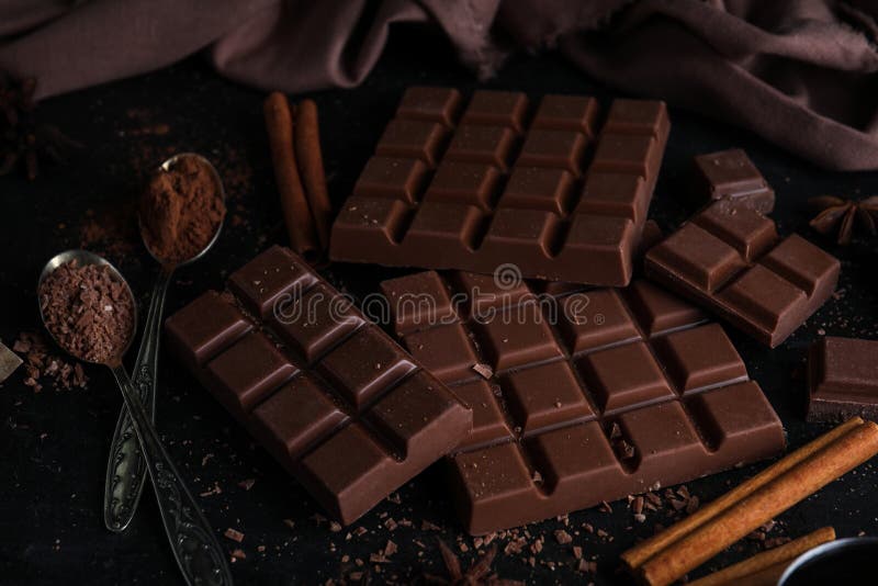 Tasty Milk Chocolate and Spoons with Cocoa Powder on Table Stock Image ...