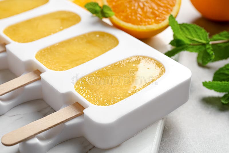 Tasty Orange Ice Pops in Mold on Light Grey Table, Closeup. Fruit ...